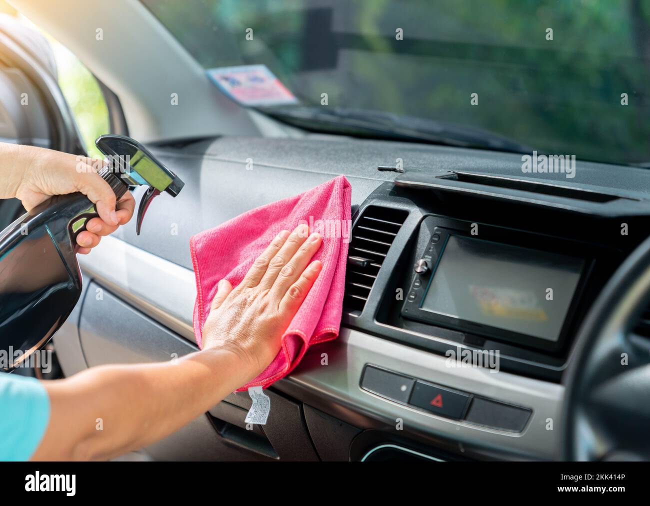 Pink microfiber cloth cleansing car interior and spraying with ...
