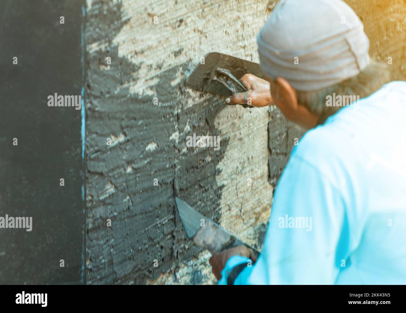 Worker plastering exposed aggregate finish wall in building site Stock ...