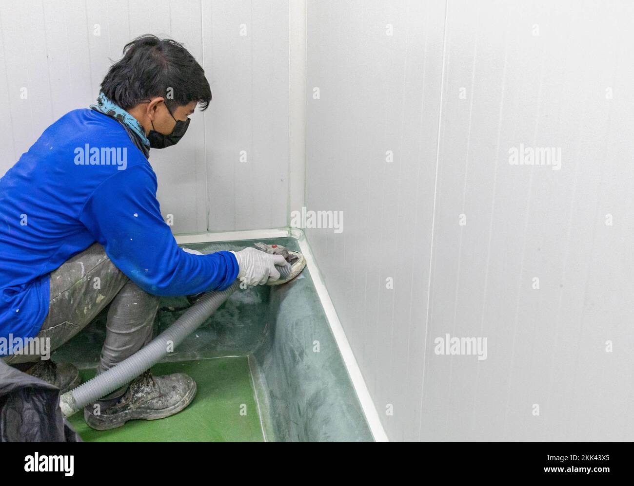 Worker polish edge bund wall before coating resin epoxy in cooling room ...