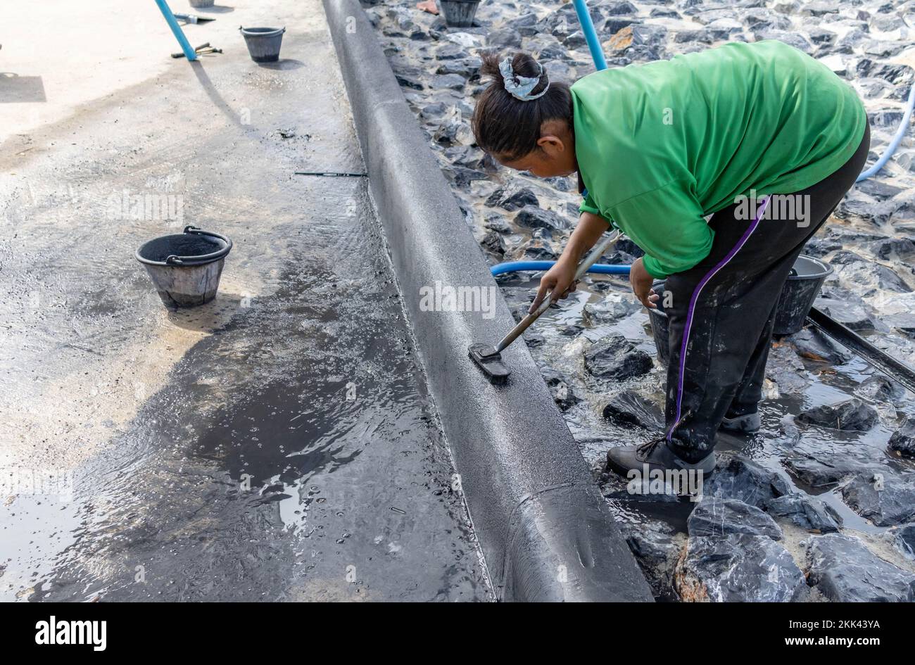Worker polish surface exposed aggregate finish for texture of footpath ...