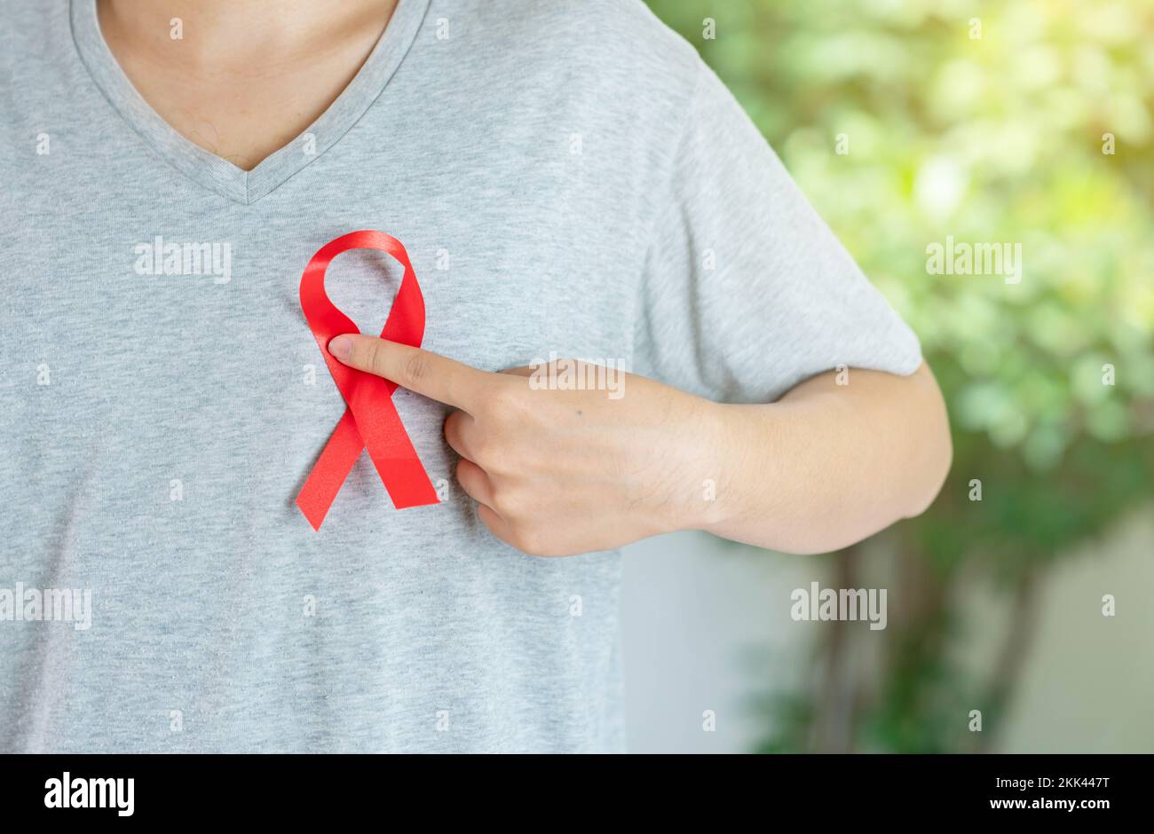 The young man point red ribbon on chest, out of focus background ...