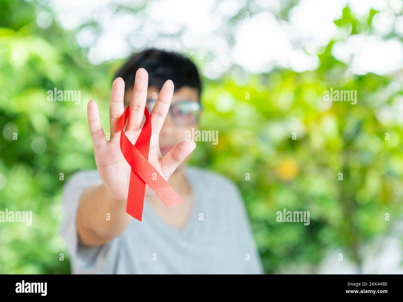 The man show red ribbon in hold hand symbol stop aids on out of focus ...