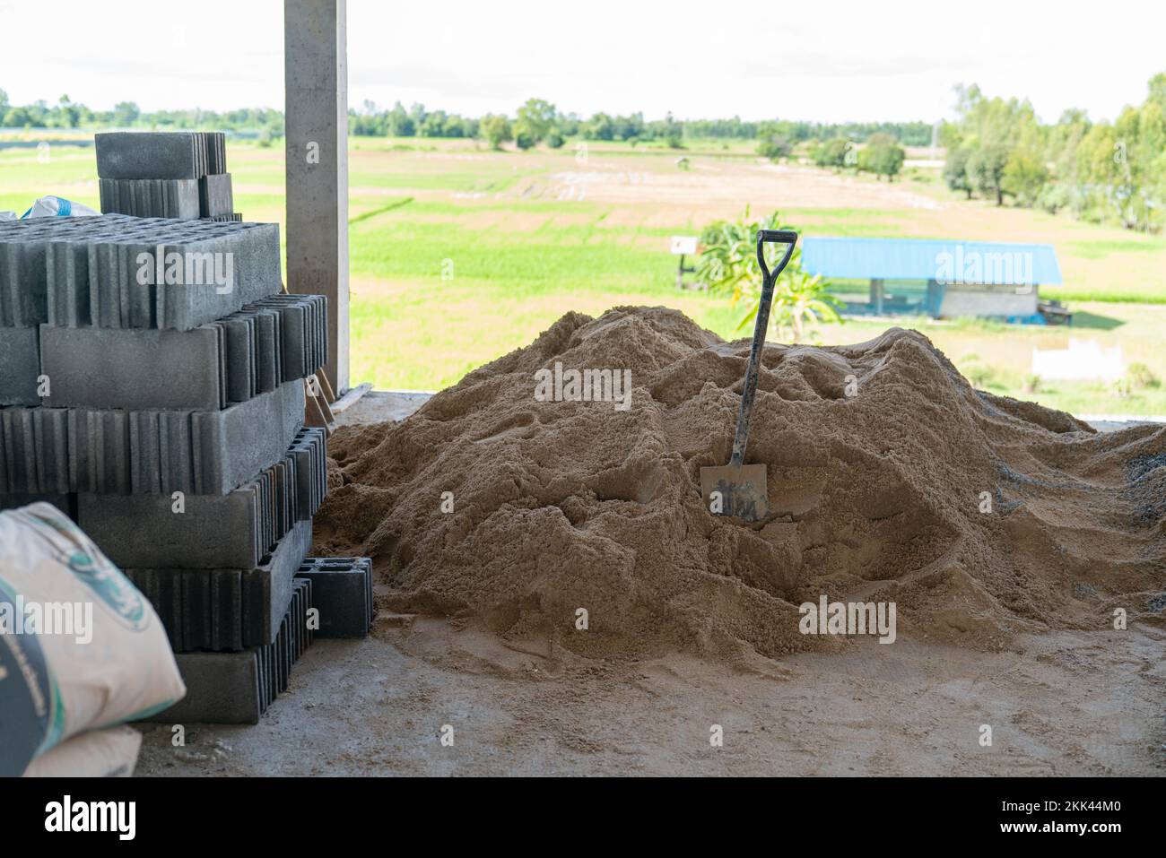 Block brick and shovel on pile of sand in building site. concrete ...
