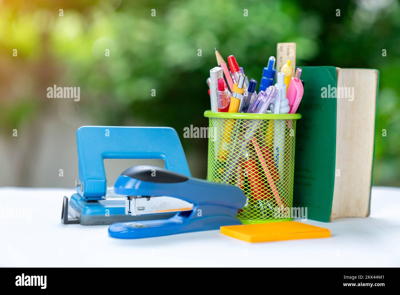 School and office stationary on out of focus green tree background ...