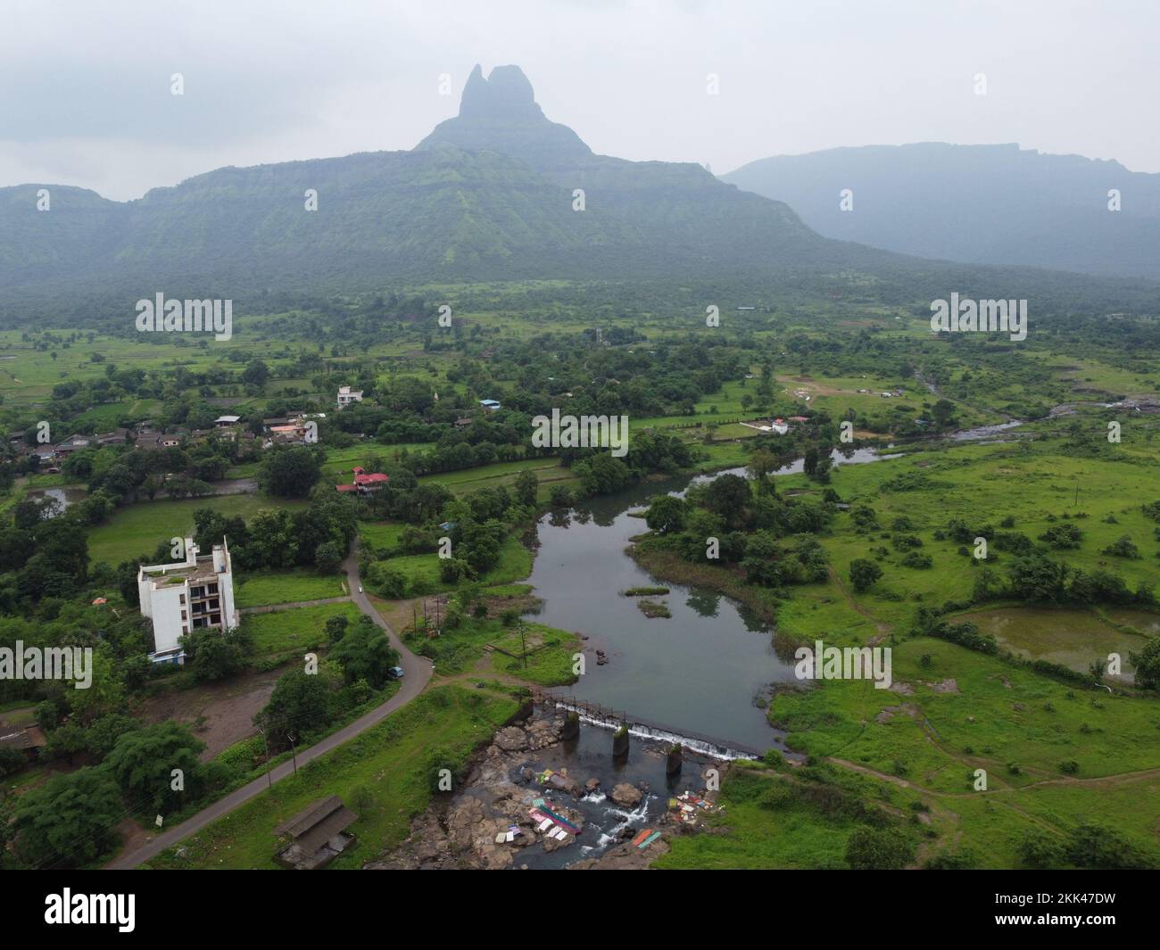 An aerial view of the river and greenery before the silhouettes of ...