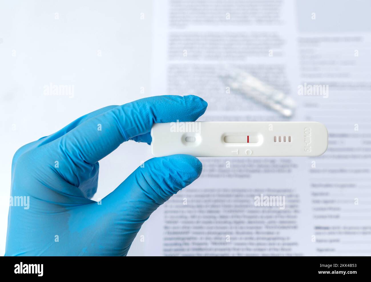Hand holding a COVID-19 rapid test with a negative result on blur ...