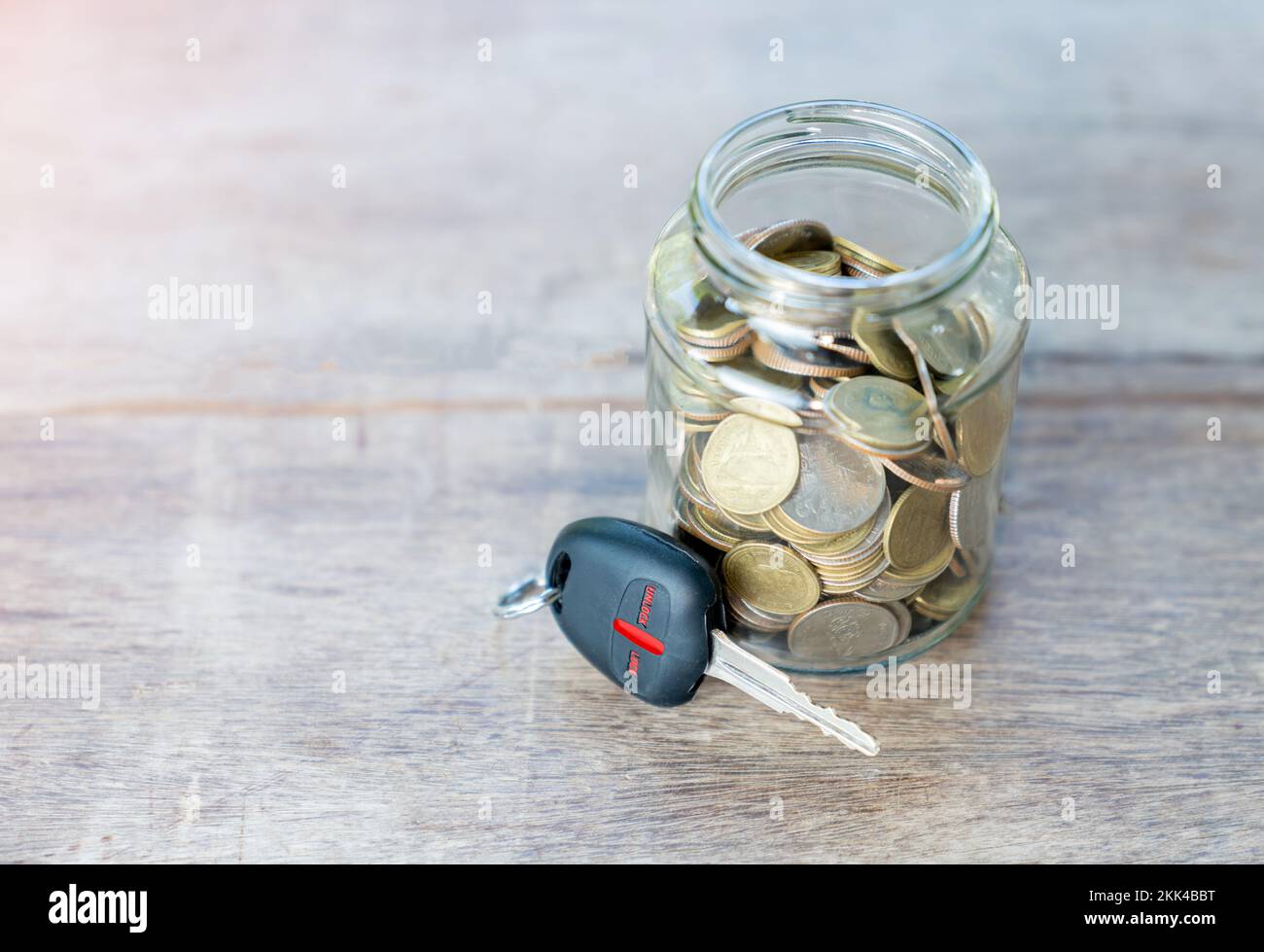 Close up of Keys car and money coin in jar place on wood table.Concept ...