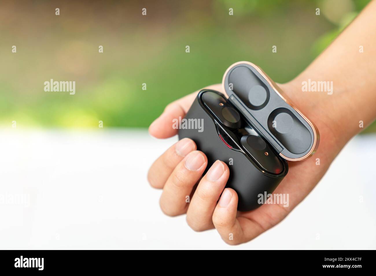 Black true wireless earphones in hand with charging case on out of ...