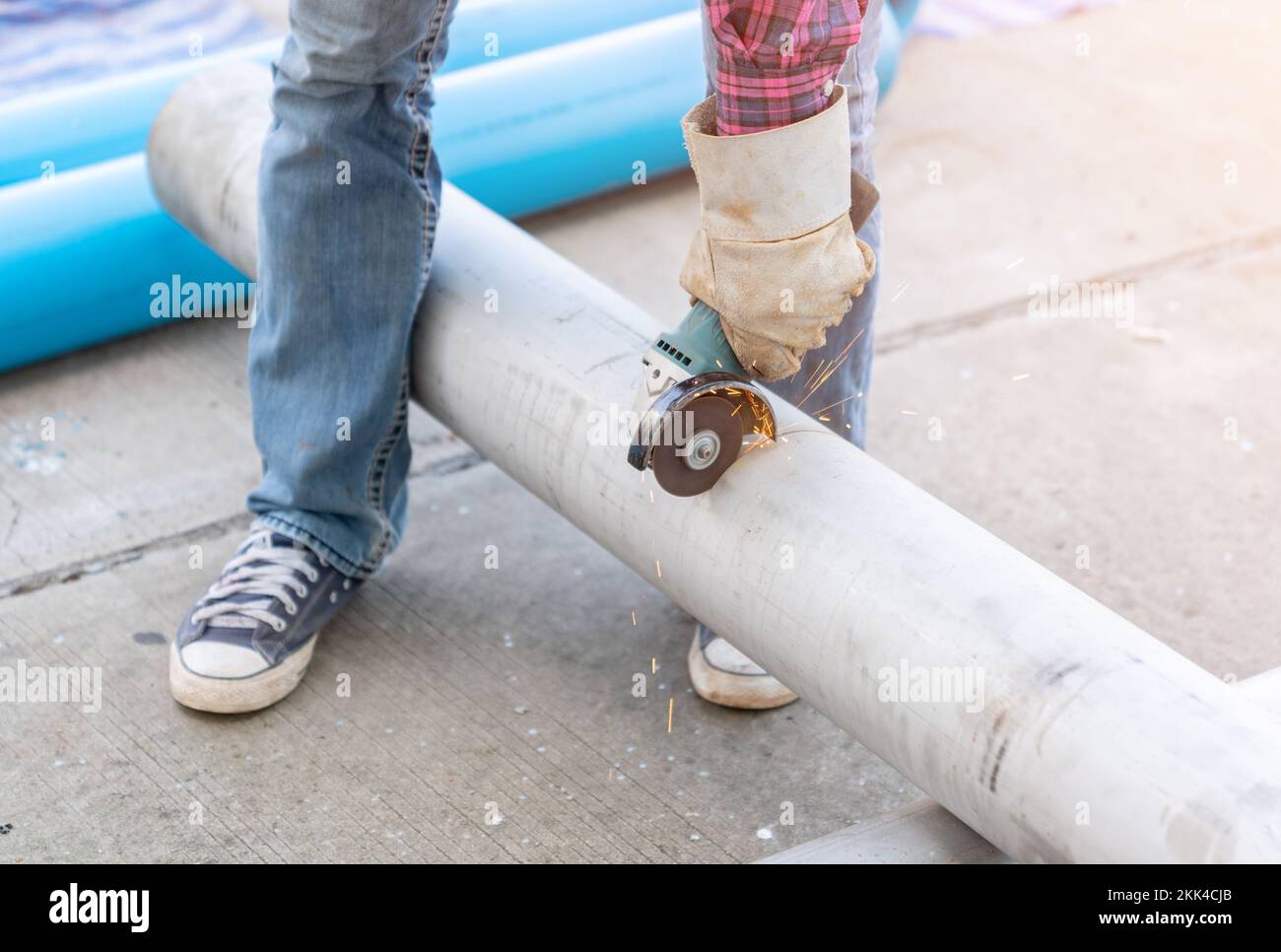 Grinder for cutting stainless pipe .One hands in gloves cut a piece of ...