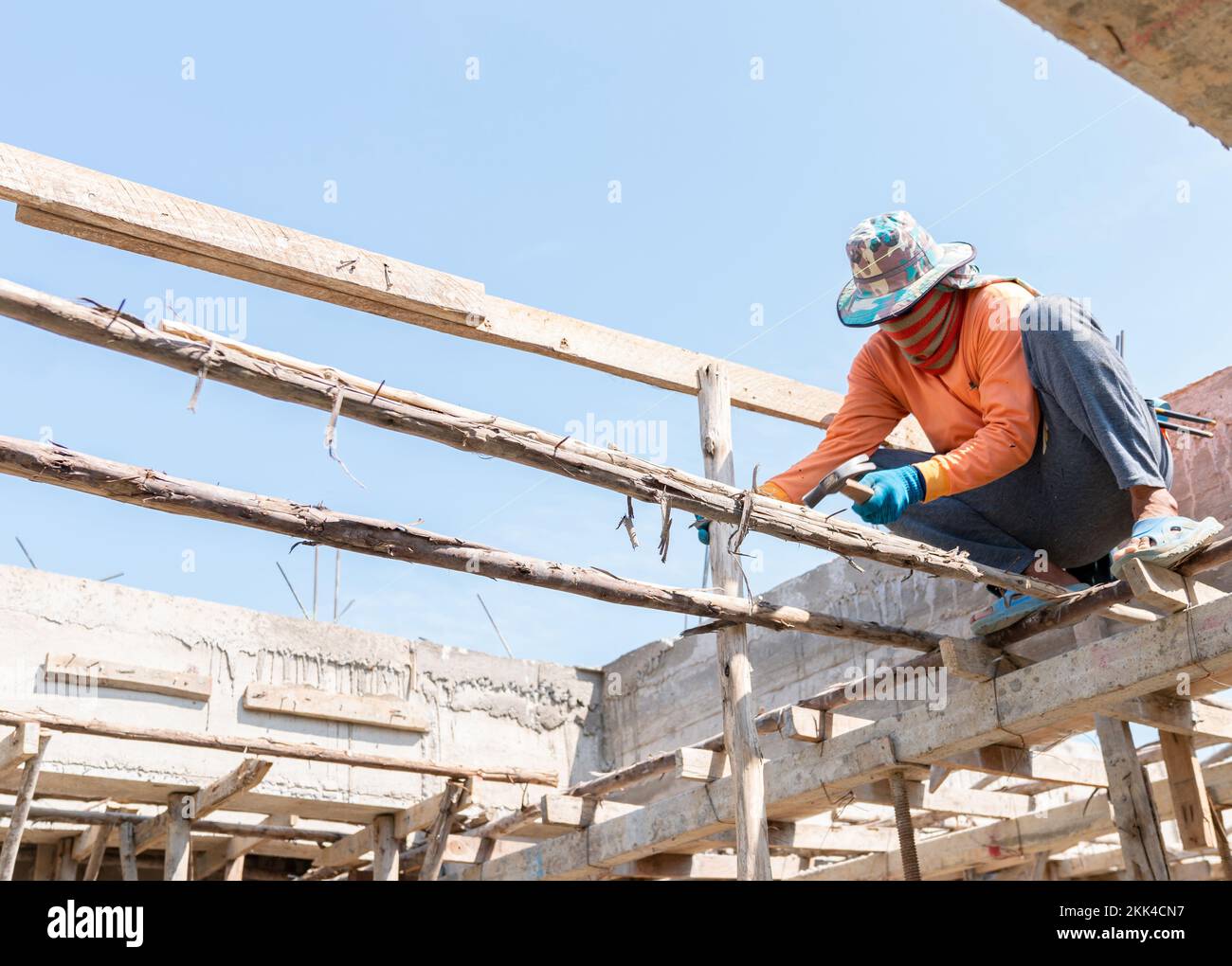 Builder hands hammering a nail into a formwork support second floor ...
