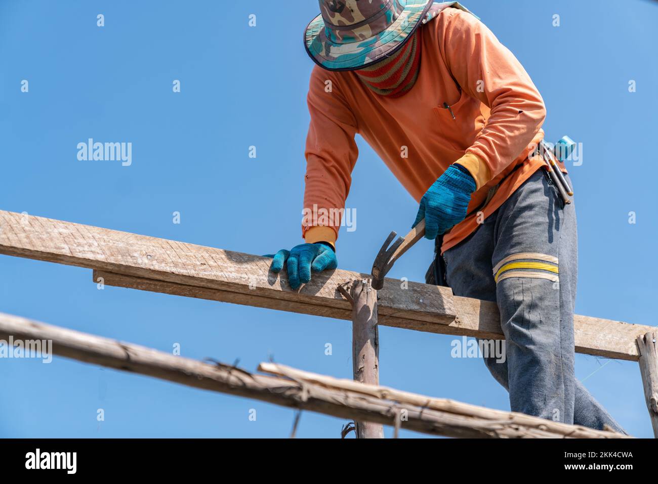 Worker use hammer hit nails on scaffolding for support second floor in ...