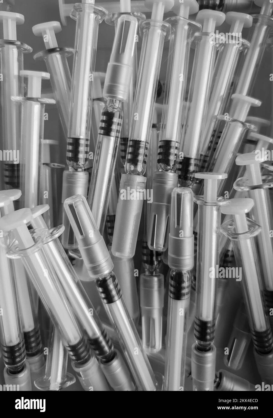 A vertical closeup of a pile of syringes in black and white Stock Photo ...