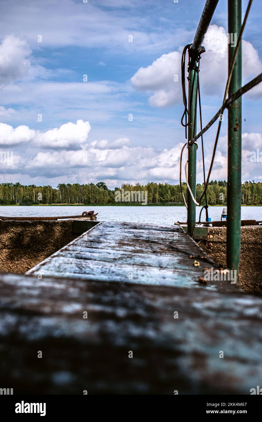 A vertical view of a narrow pathway in front of a lake surrounded by ...
