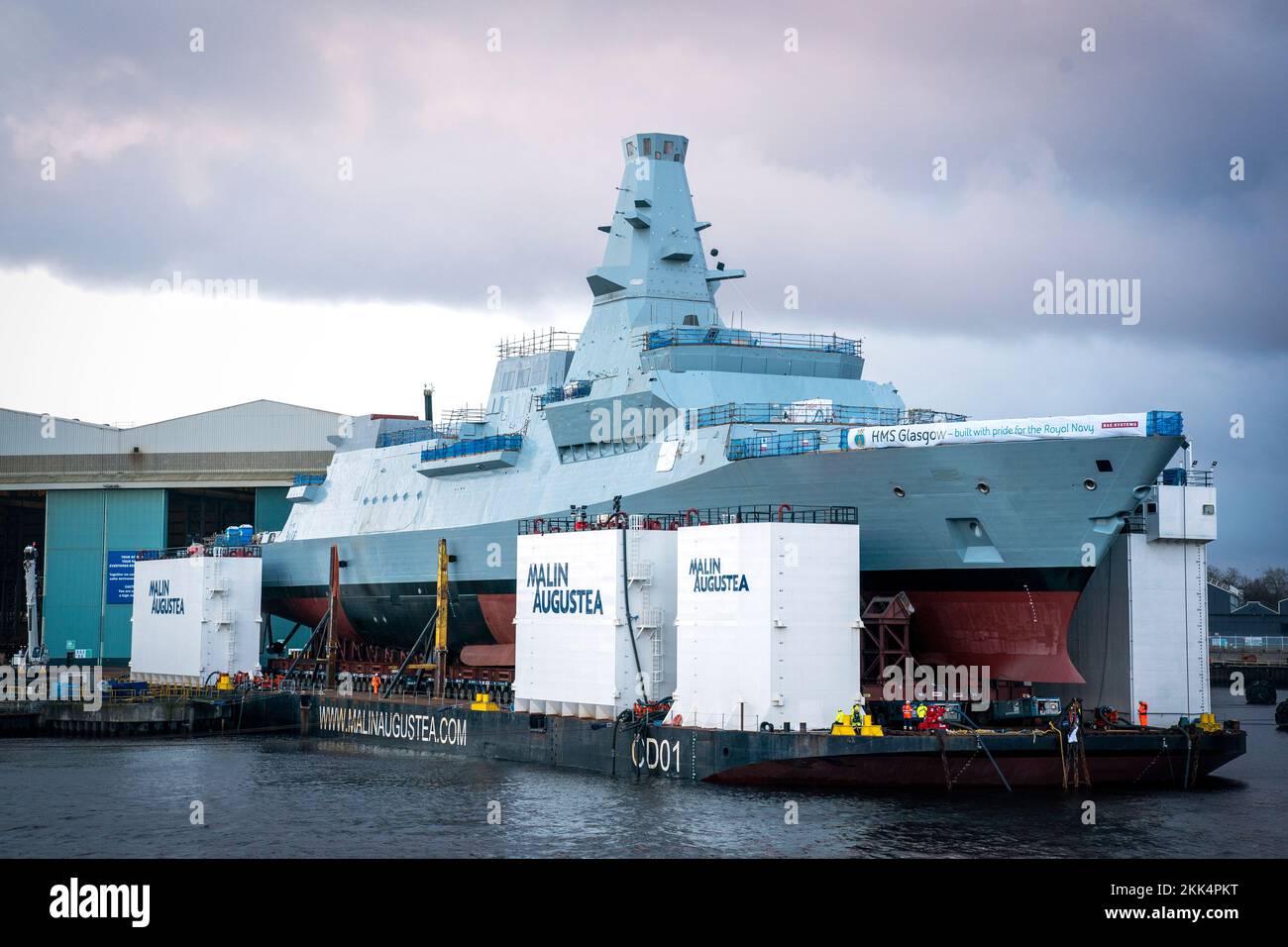 HMS Glasgow is maneuvered onto a barge at the BAE Govan shipyard in ...