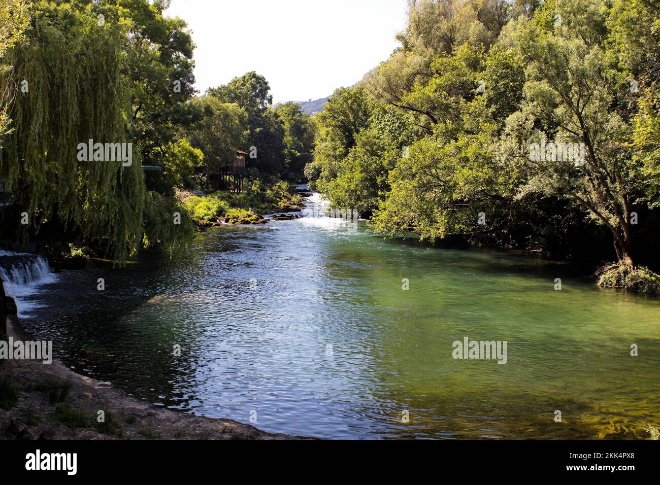 A landscape of a river surrounded by greenery under the sunlight Stock ...