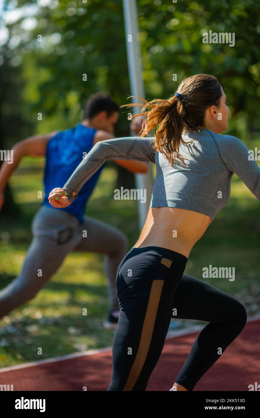 A fit female sportsperson is running in the park with her boyfriend ...