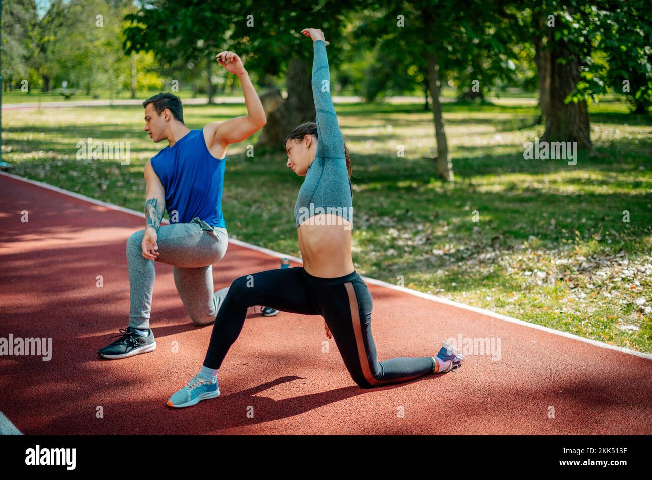 Beautiful young sporty couple is stretching their bodies. Left knee ...