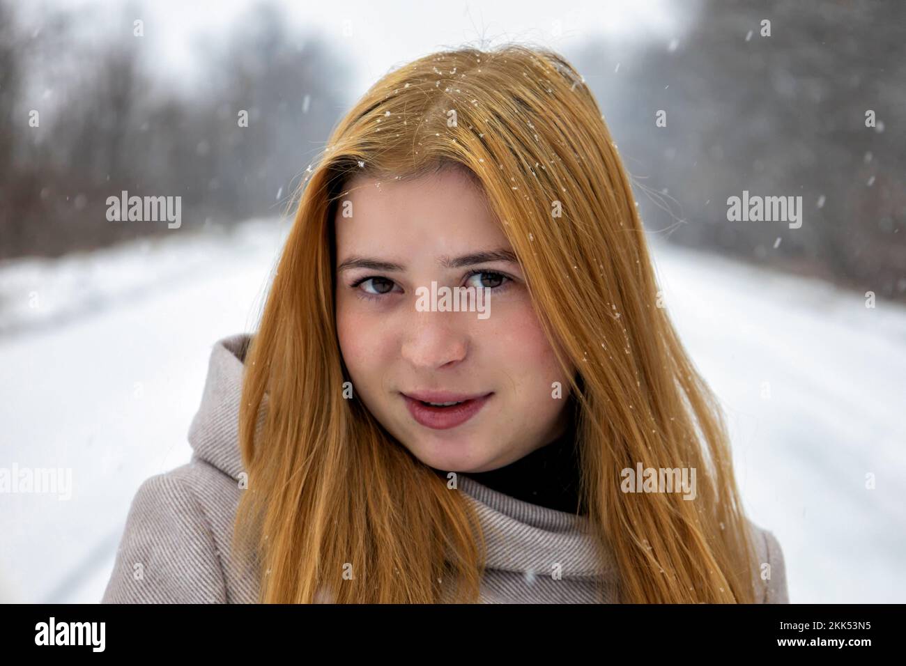 Portrait of a red-haired girl with freckles on her face. With blurred ...