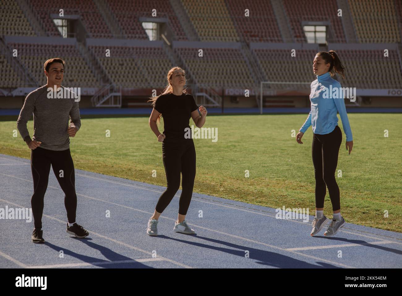 Three people are training at the stadium, together Stock Photo - Alamy