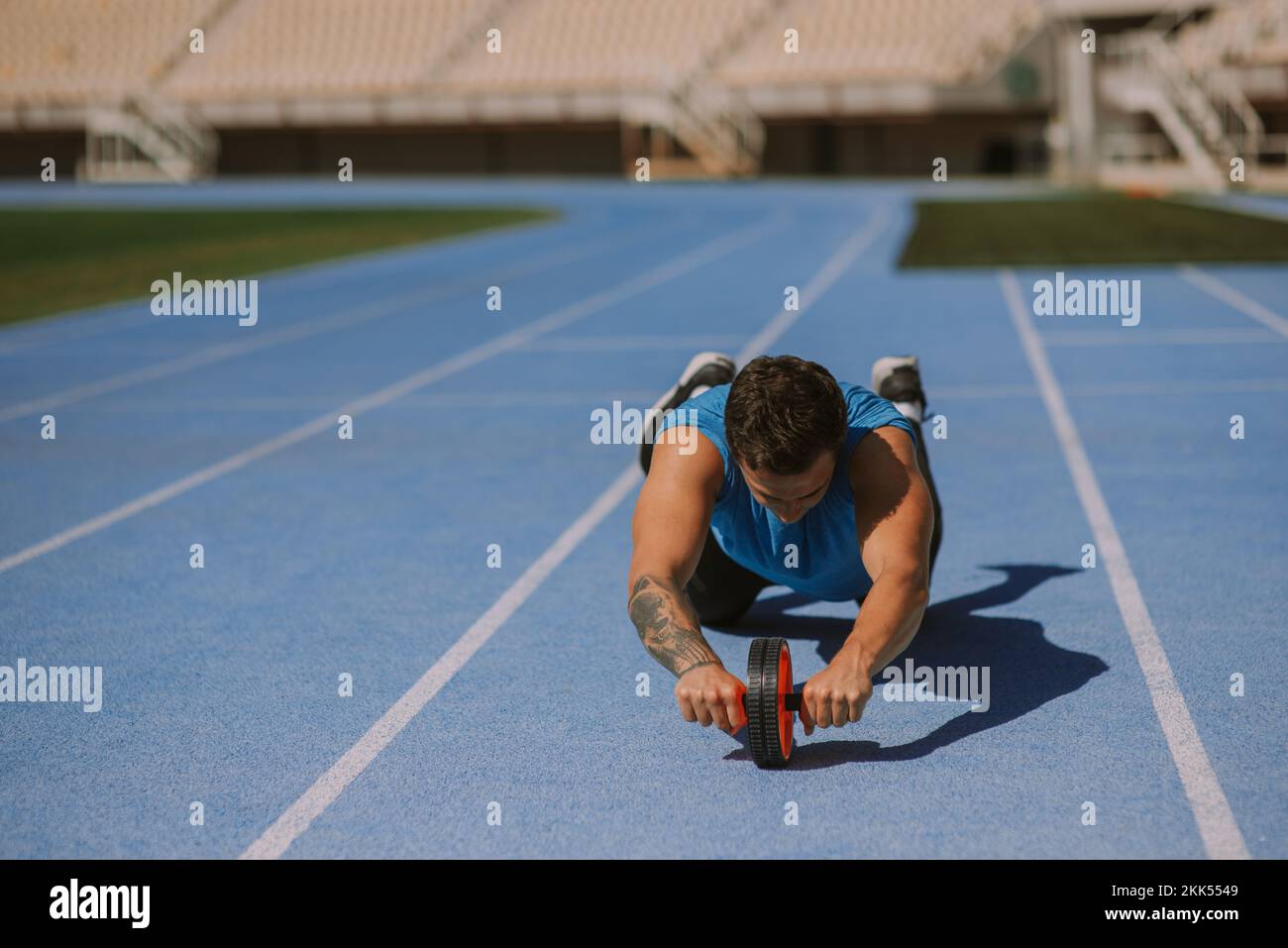 A handsome male person is training with his ab wheel roller. He is ...