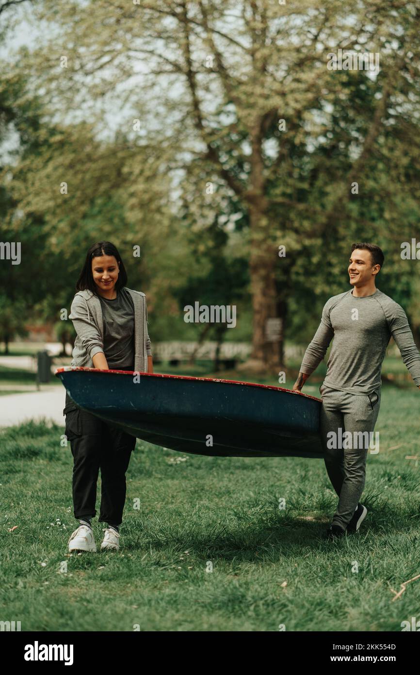 Beautiful couple carrying the red kayak while walking in the park and ...