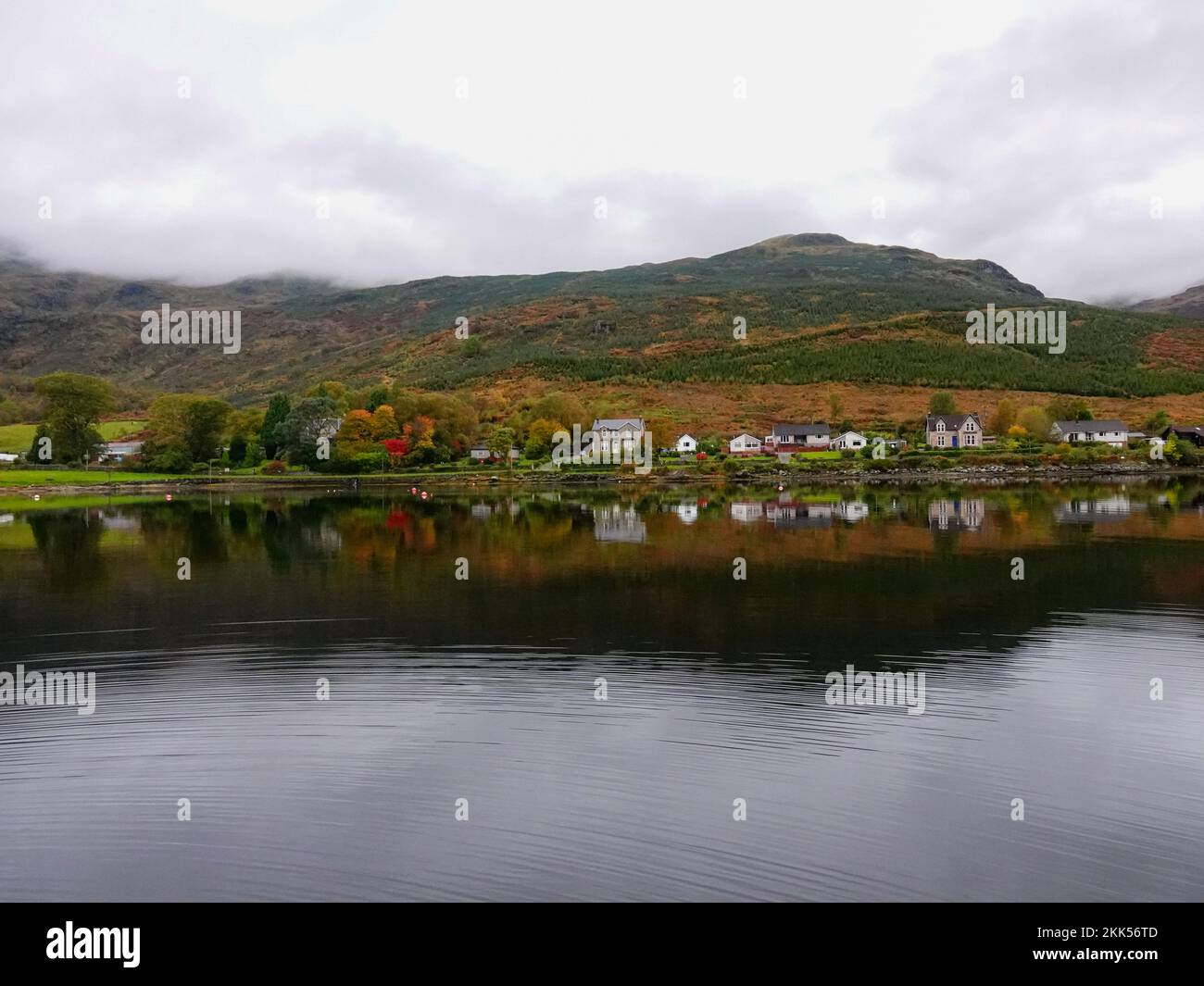 Village of Carrick Castle, with hills and fog reflecting in Loch Goil ...