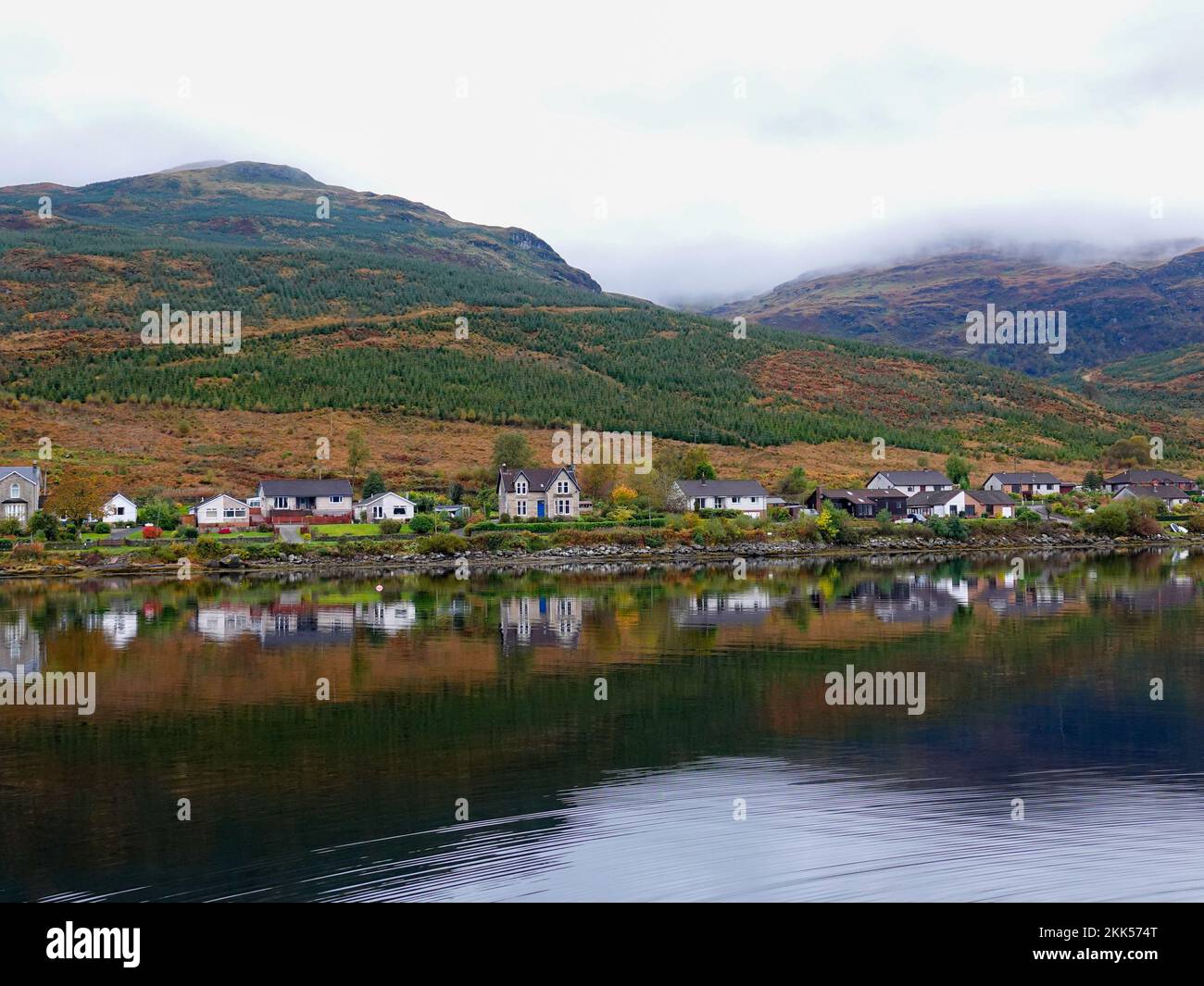 Morning fog and mountain reflections, houses in the village of Carrick ...