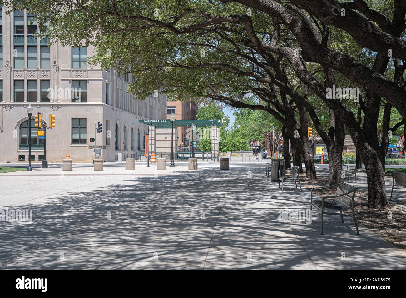 A sidewalk surrounded by greenery and buildings on a sunny day in ...
