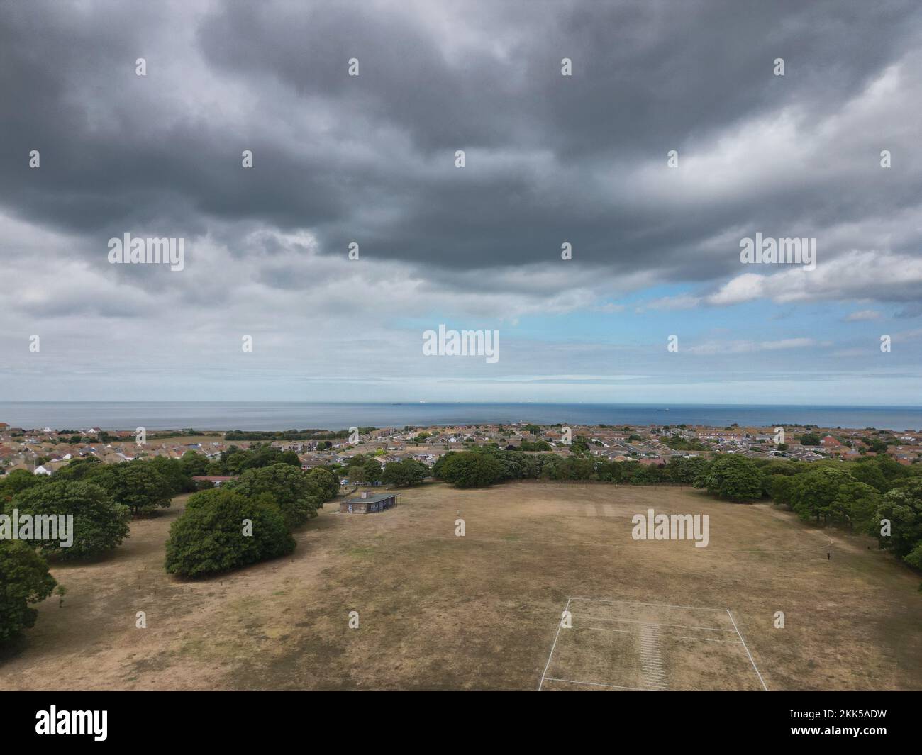 An rural area with leafy trees under a cloudy sky Stock Photo - Alamy