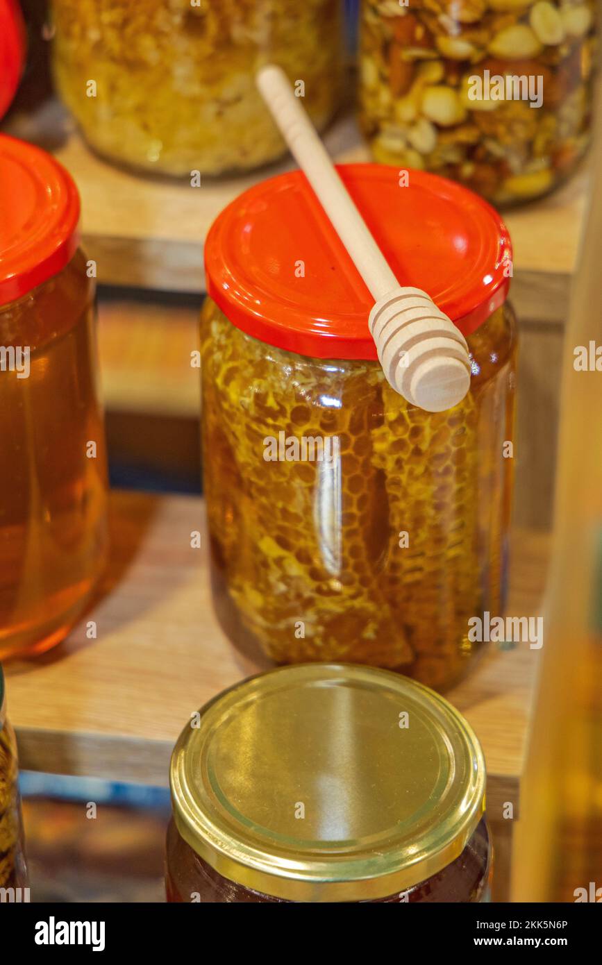 Wooden Honey Dipper Spoon at Jar With Honeycomb Stock Photo - Alamy