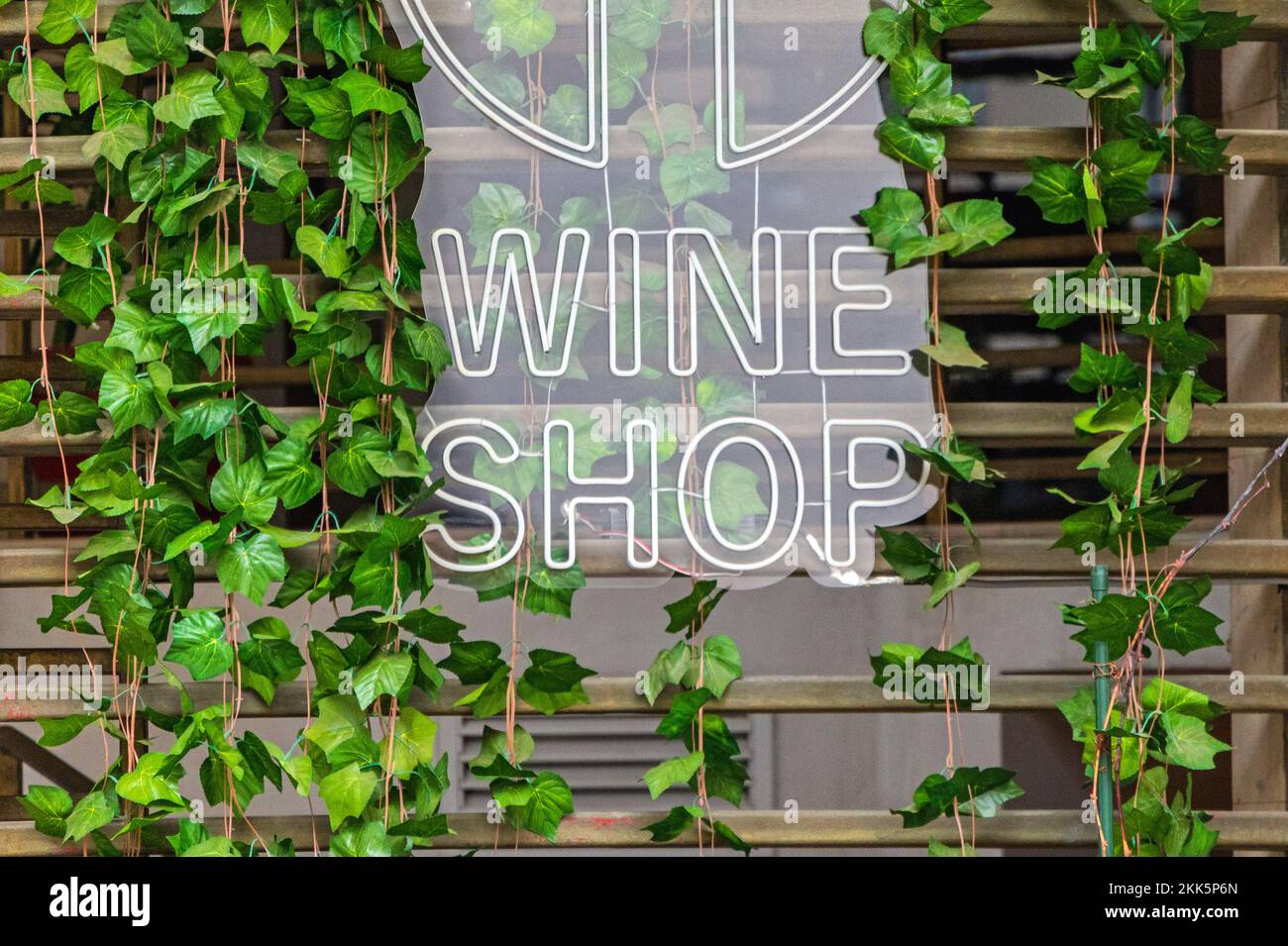 White Neons Wine Shop Sign Exterior With Plants Stock Photo - Alamy