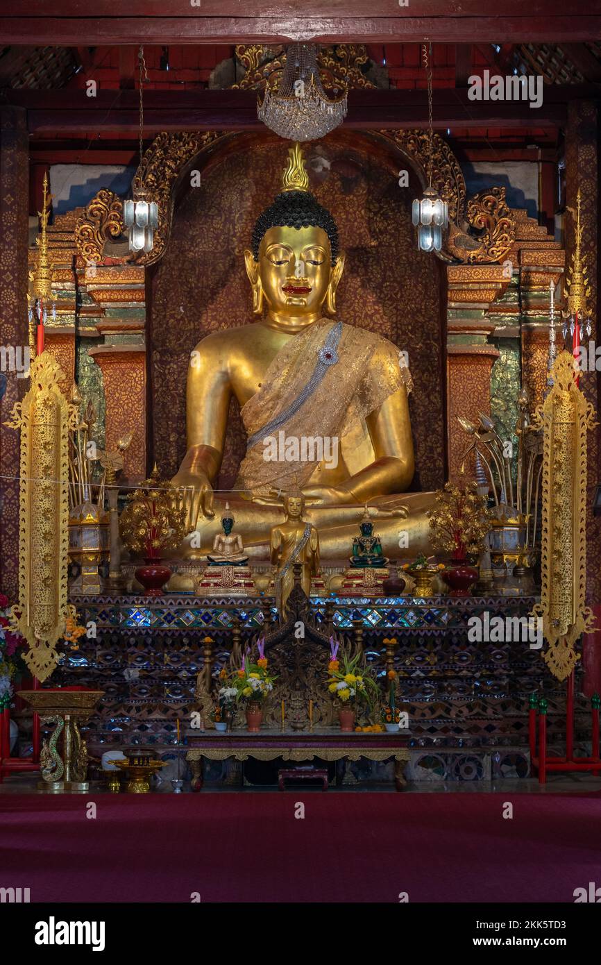 Ancient golden Buddha statue with red and gold background inside vihara ...
