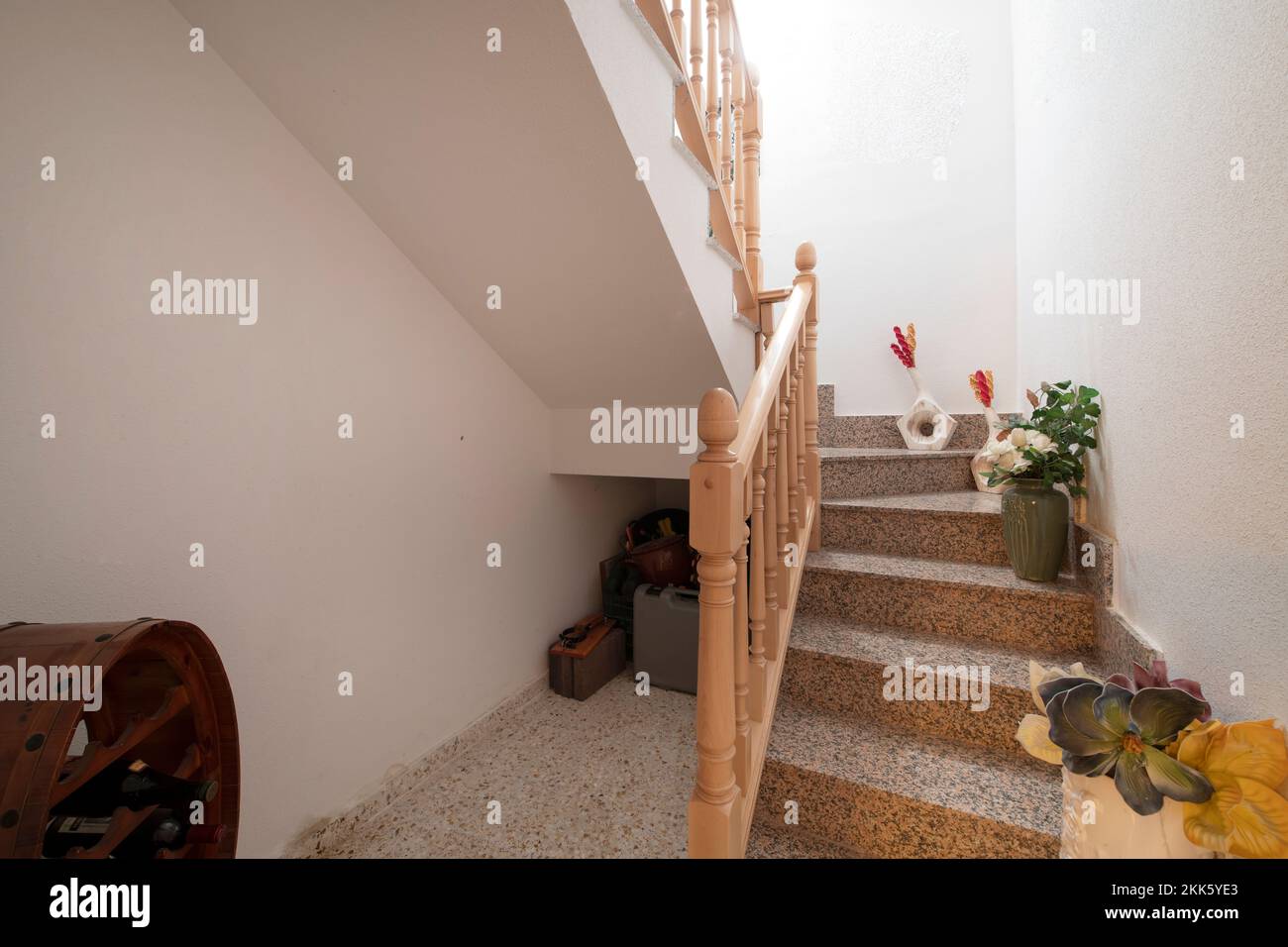 Staircase interior of detached house with pink granite floors, raw wood ...