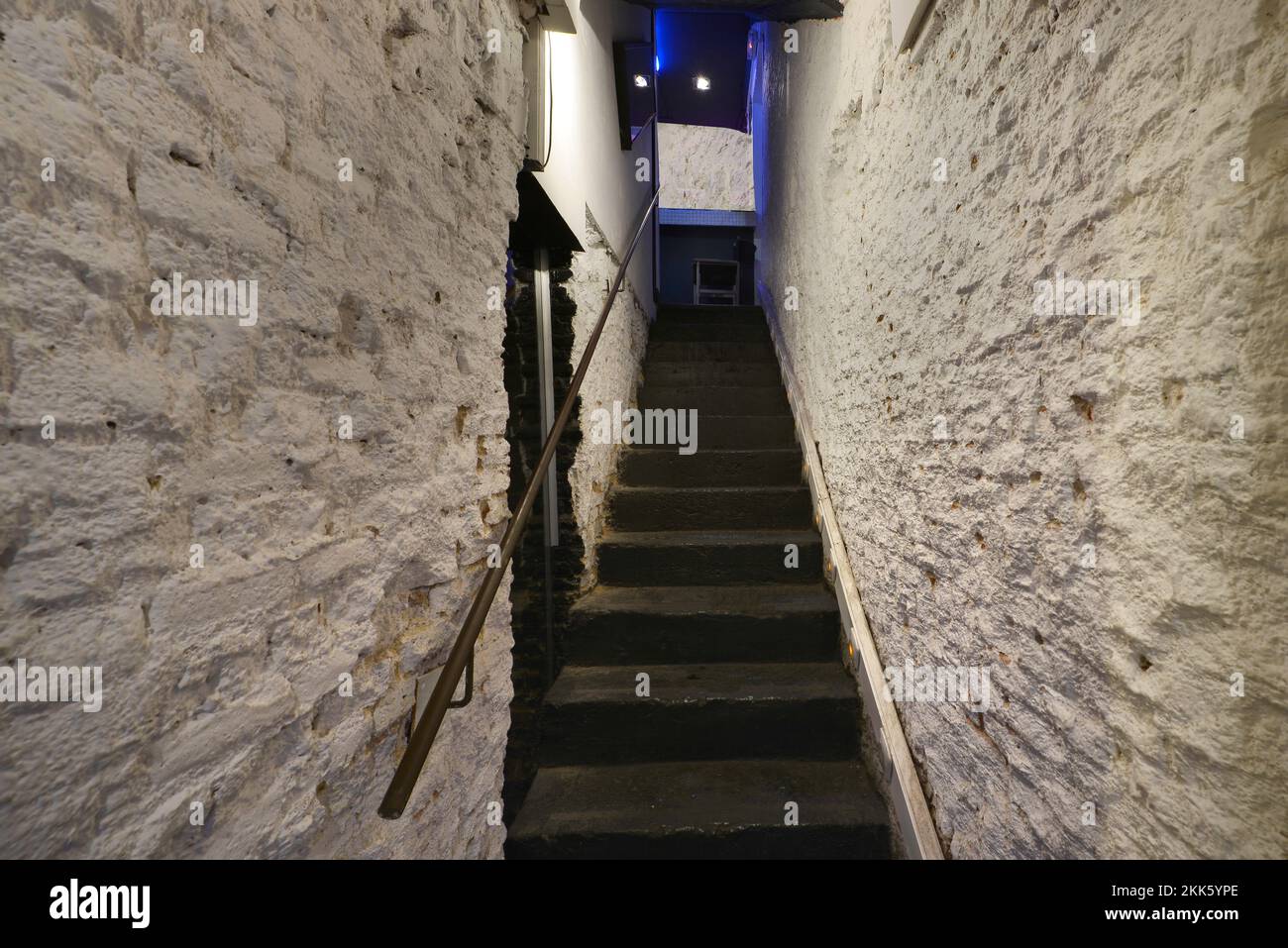 Staircase interior of a nightclub with white chipped brick walls and ...