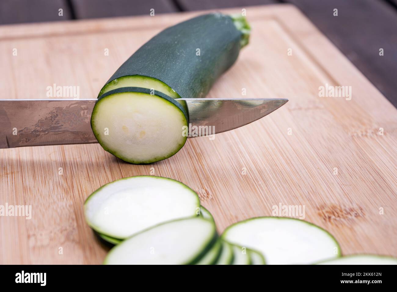 Zucchini sliced with a sharp knife on a bamboo board Stock Photo - Alamy