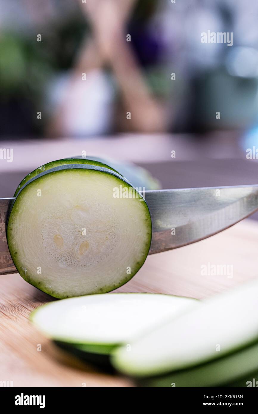 Zucchini cut into many thin slices with a sharp knife on a bamboo board ...