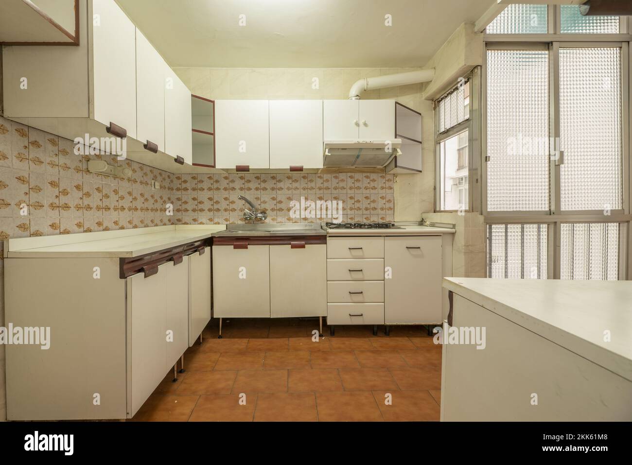 Kitchen with old white furniture, aluminum partitions with translucent ...