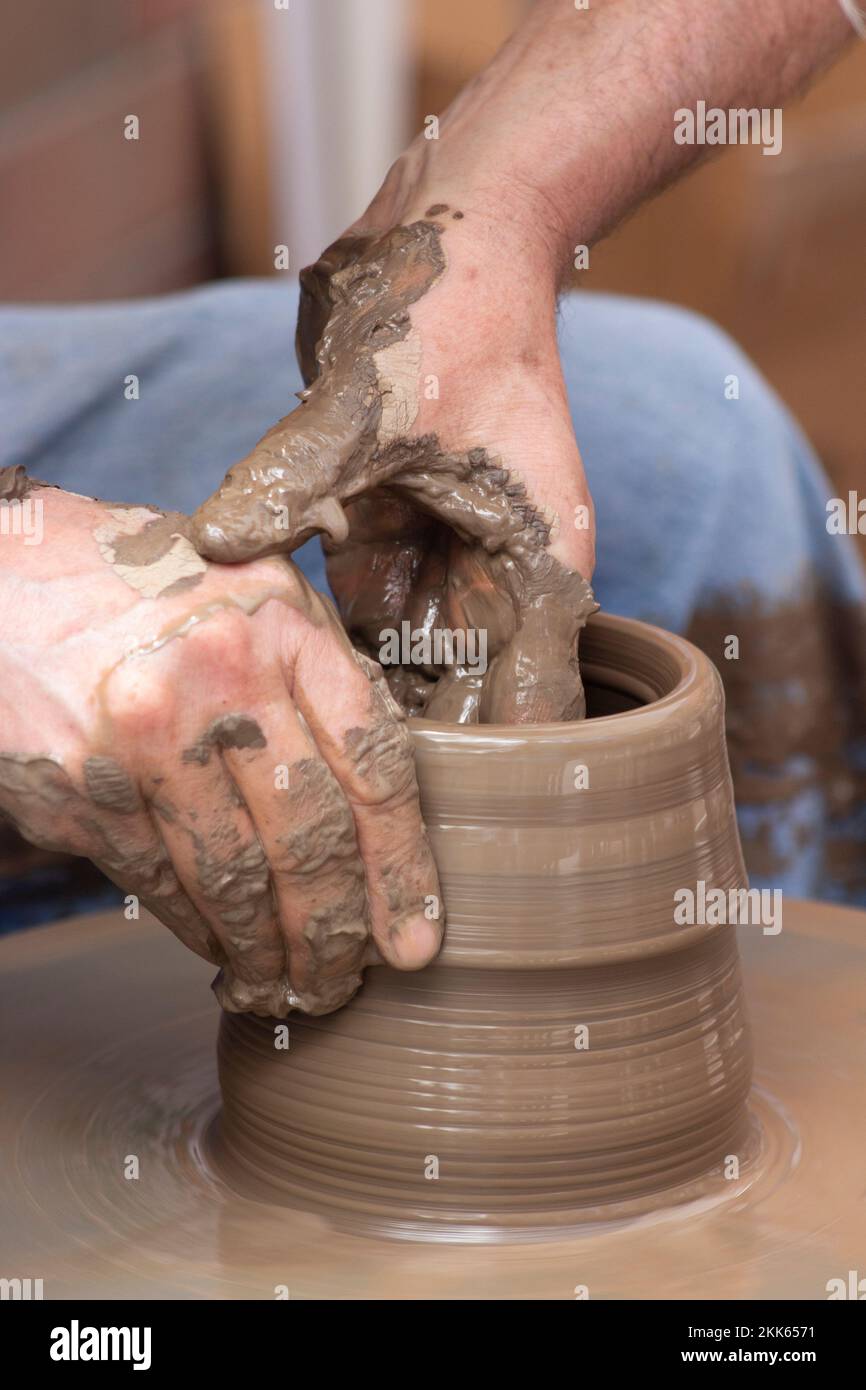 A vertical shot of the potter's hands giving shape to the clay Stock ...