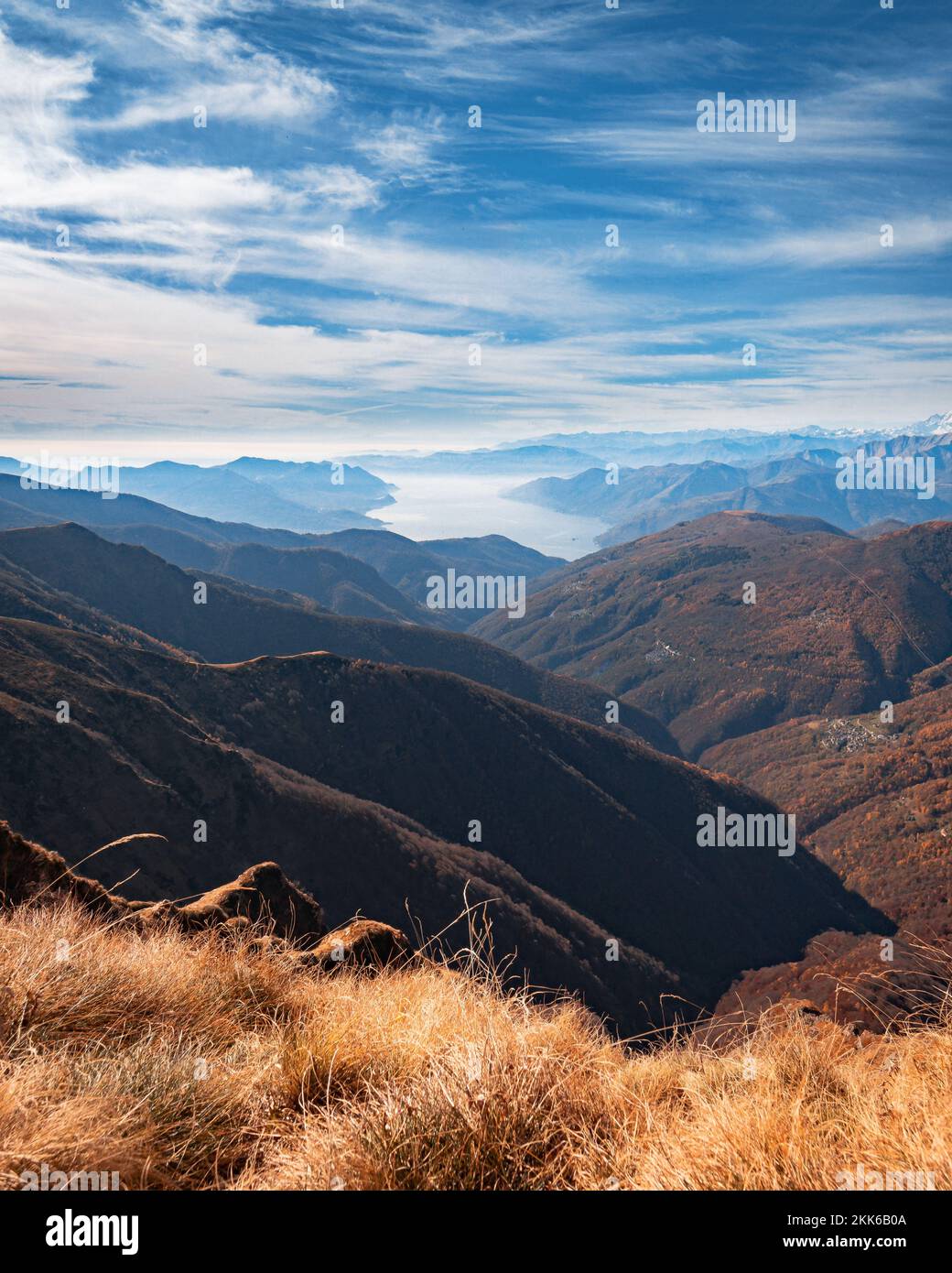A vertical footage of a range of mountains with a blue sky and clouds ...