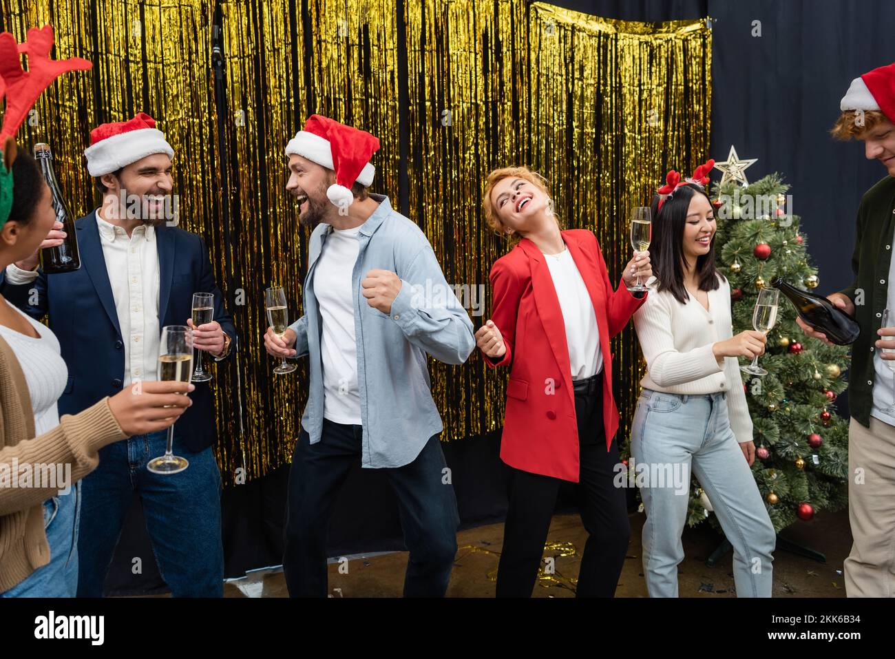 Multiethnic business people with champagne dancing during Christmas ...