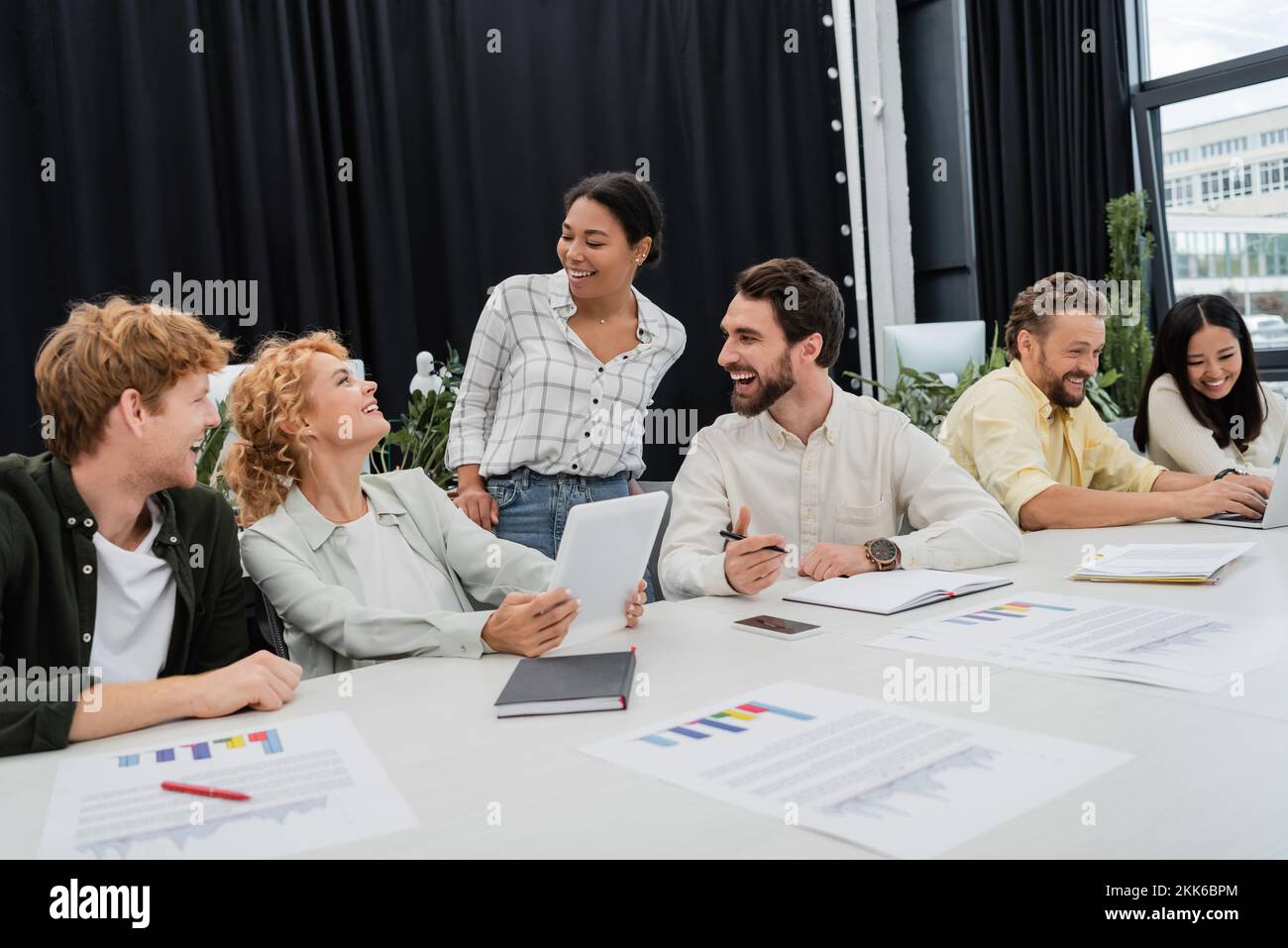 cheerful multicultural business people laughing near conference table ...