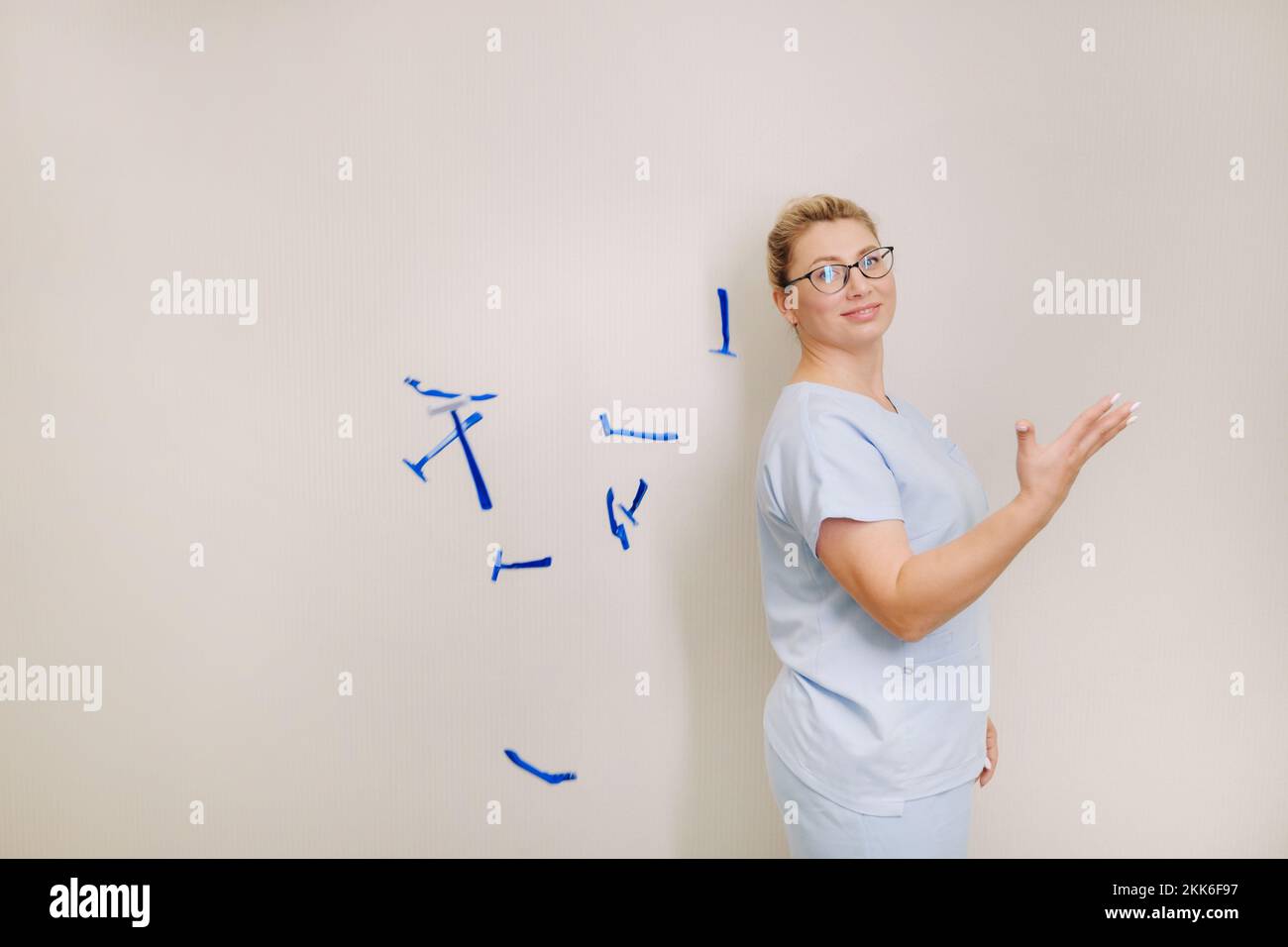a female laser hair removal master in a blue robe throws shaving ...