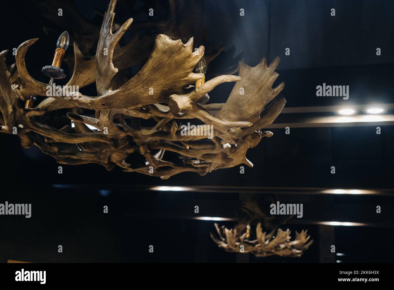 A chandelier made of deer antlers hanging on the ceiling of the ...