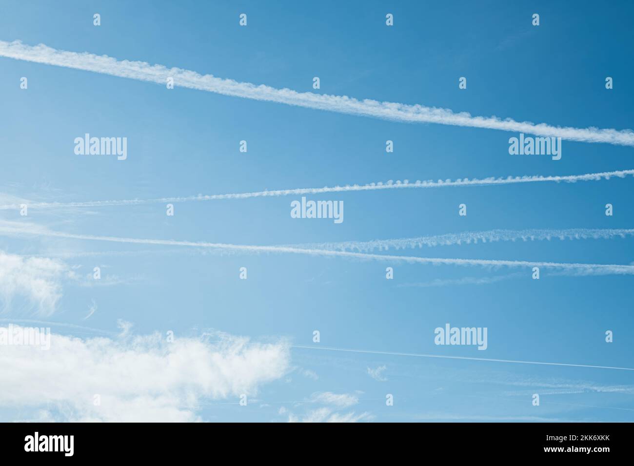airplane trails of condensed air crisscrossing each other against the ...