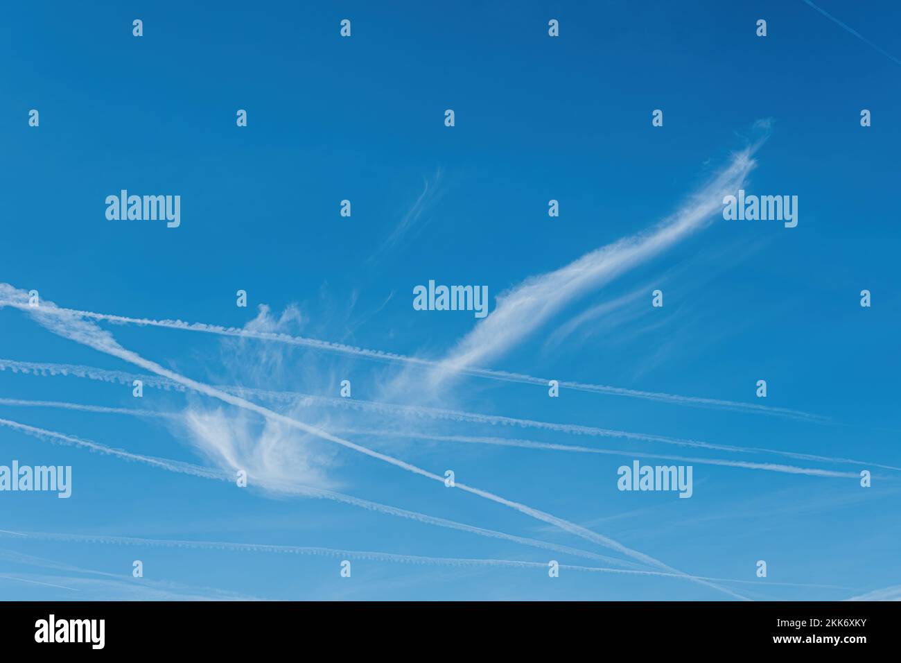 airplane trails of condensed air crisscrossing each other against the ...