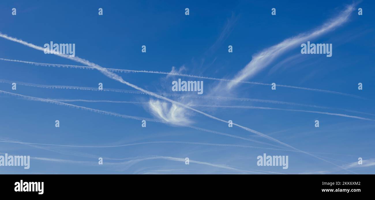 airplane trails of condensed air crisscrossing each other against the ...