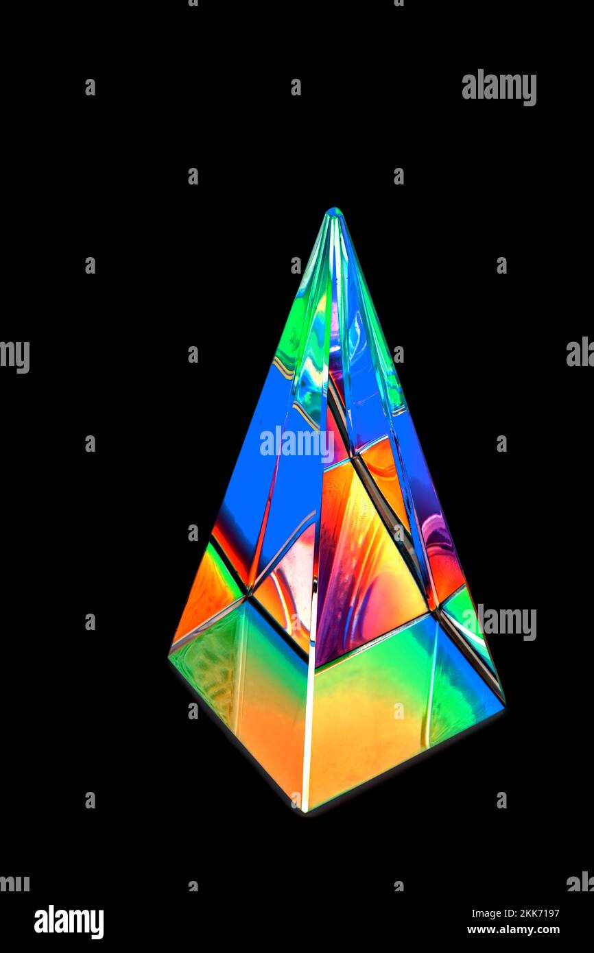 Glass pyramid prism with colorful light reflection on black background ...