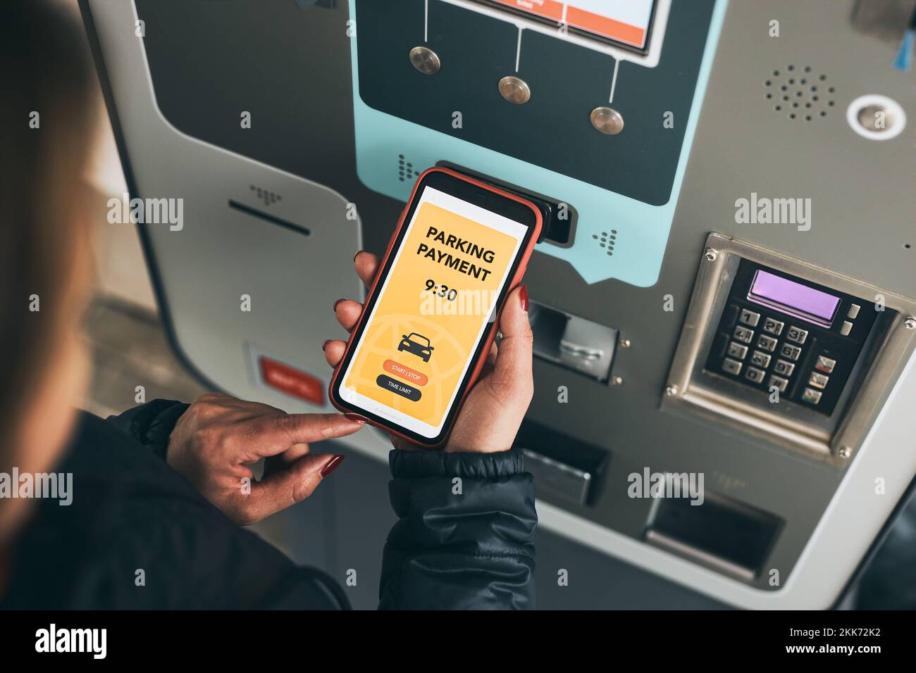 Woman paying for parking ticket at car parking payment machine using ...
