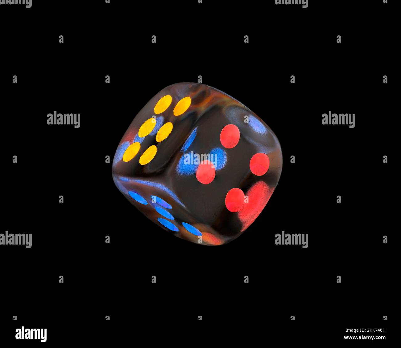 plastic transparent dice cube with colored dots on black background ...