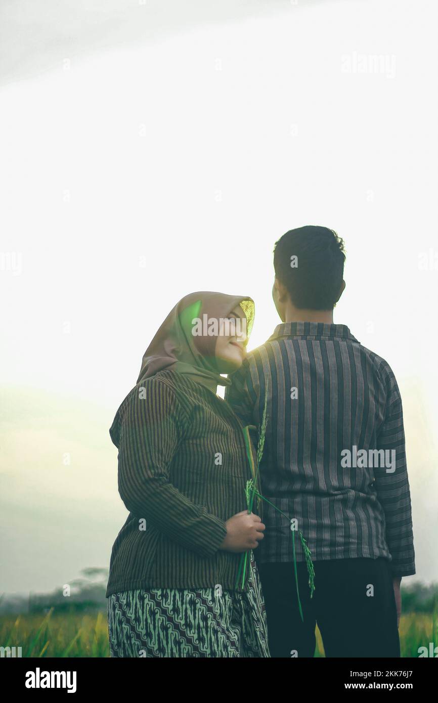 A couple of Asian standing side by side in traditional Javanese ...